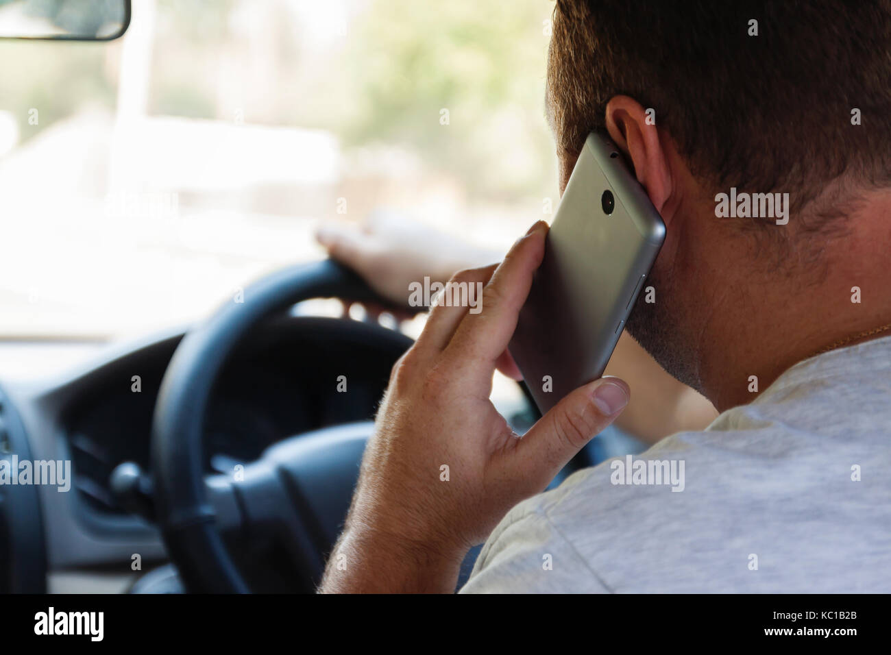 man talking on a cell phone while driving a car Stock Photo - Alamy