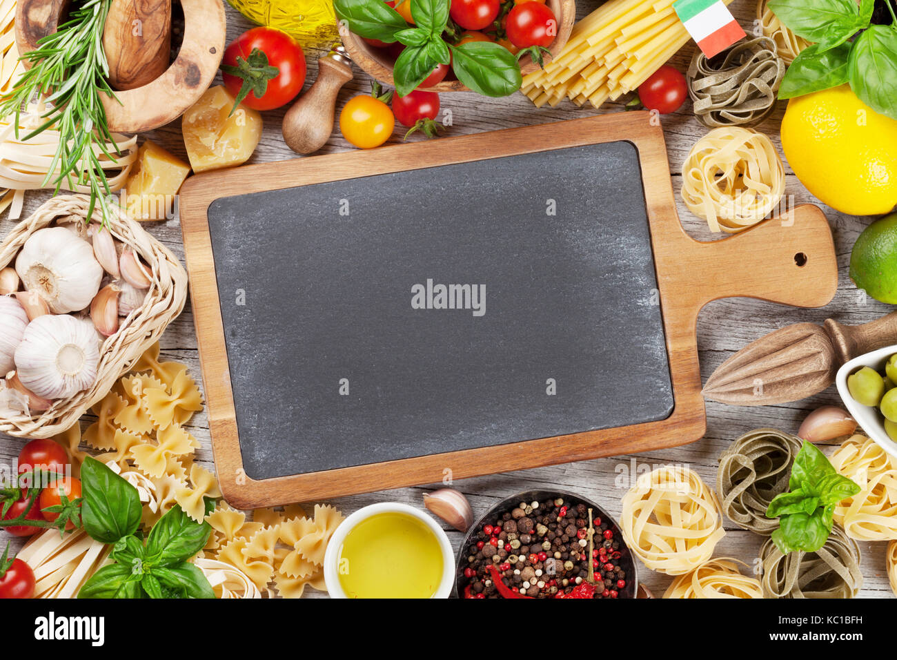 Italian food. Pasta ingredients on wooden table and blackboard. Top ...