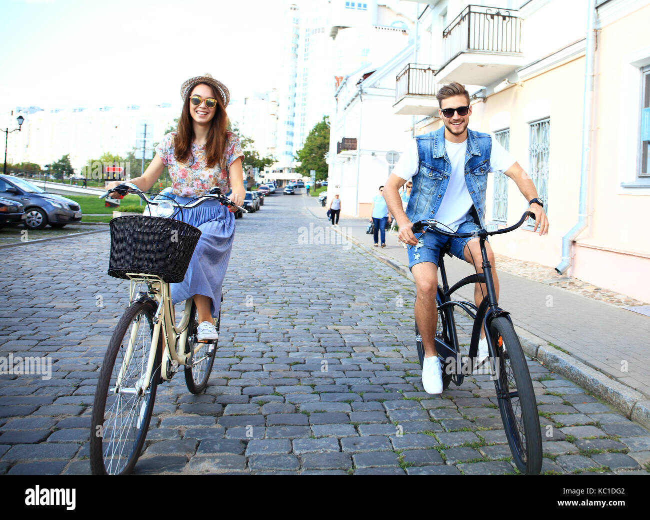 Happy funny young couple riding on bicycle. Love, relationship, romance ...