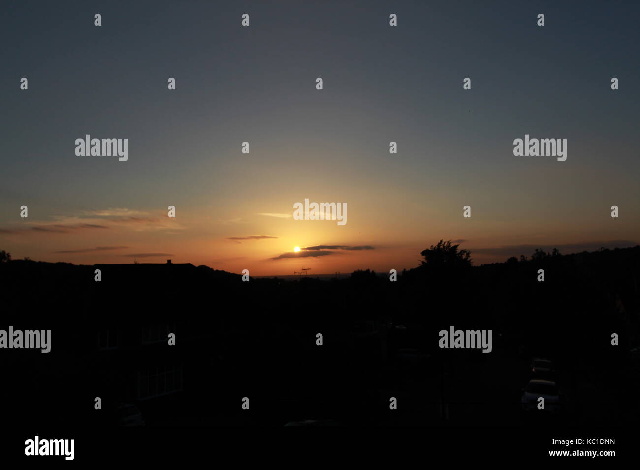 Sunset over a town at dusk Stock Photo - Alamy