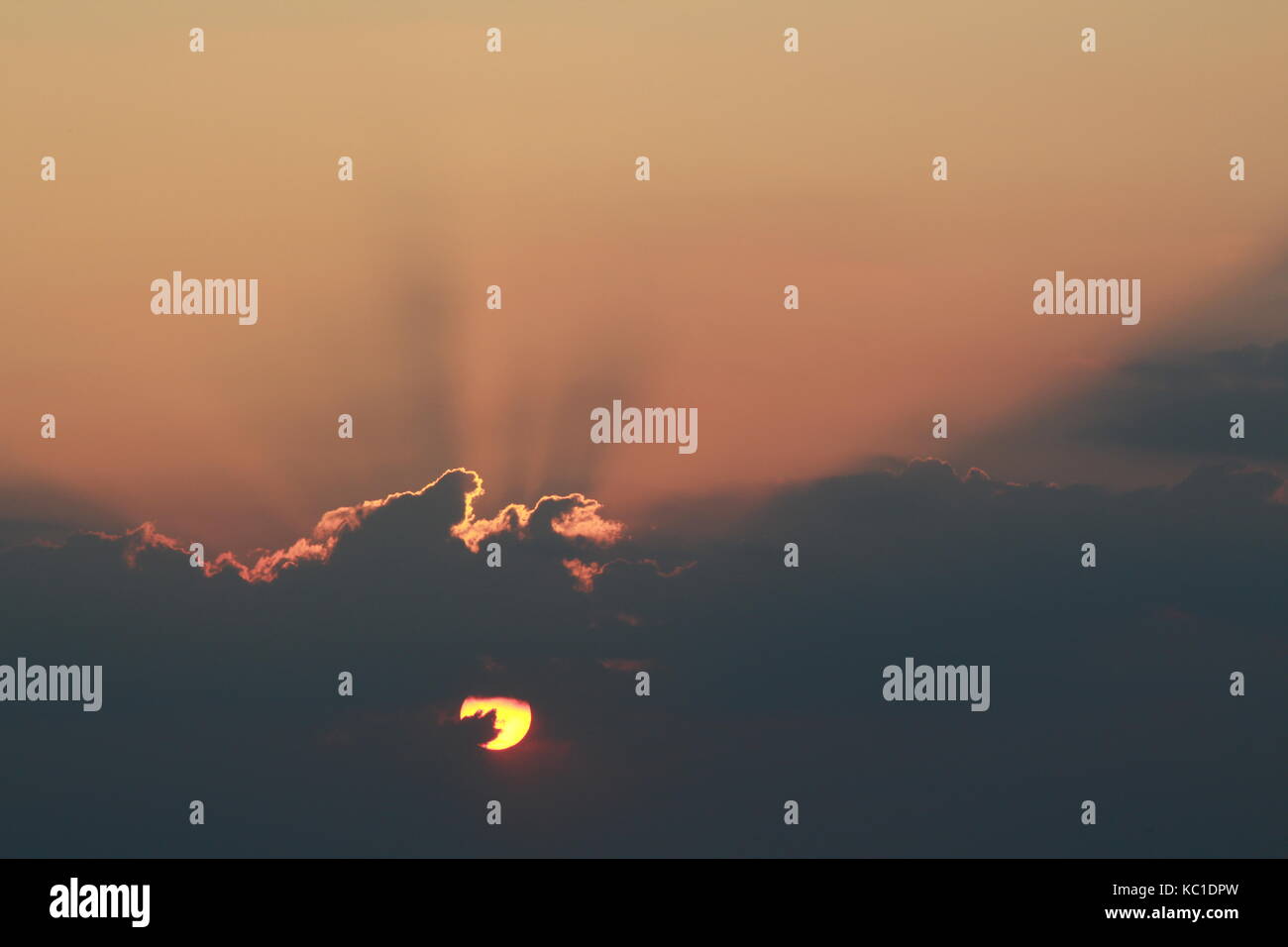 Beautiful sunset through the clouds Stock Photo - Alamy