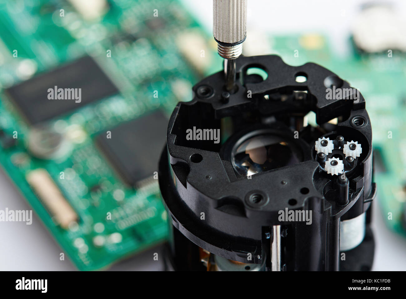 Closeup of screwdriver dissassembling DSLR lens. Mechanism of focus ...