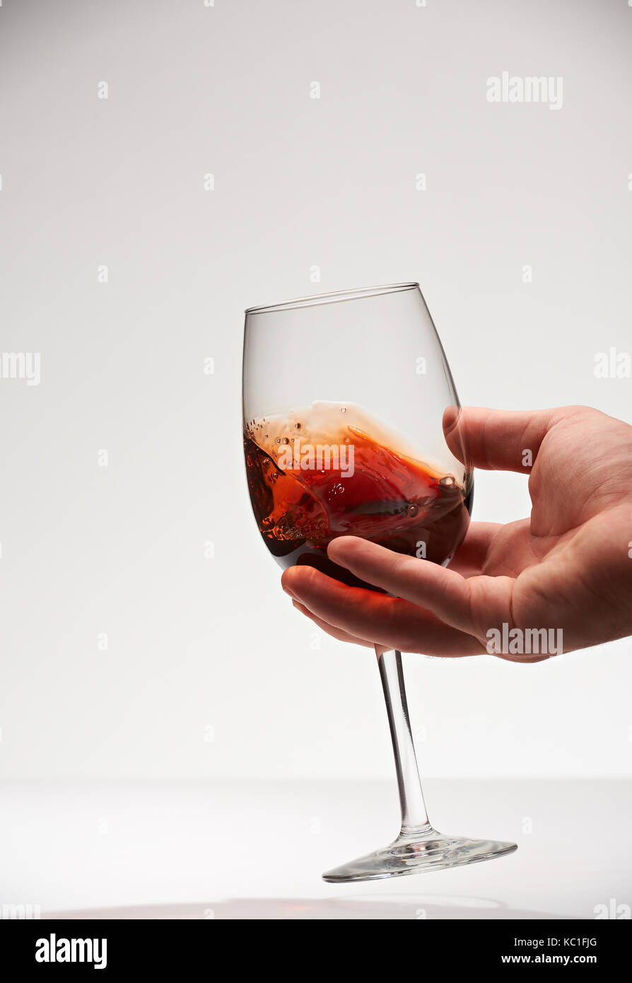 Sweet red wine hand holding in glass isolated on white background Stock ...