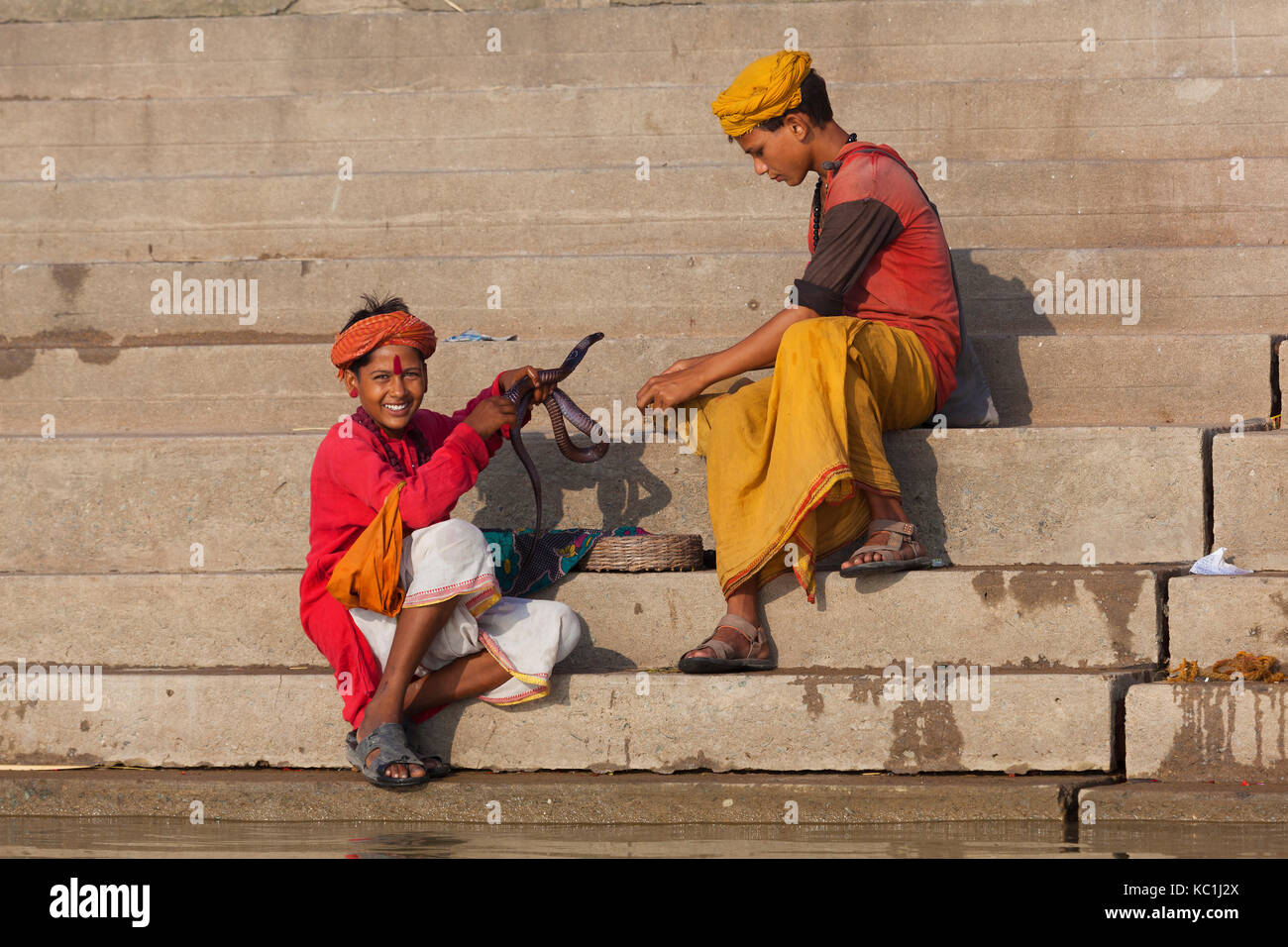 Children with cobra at ghat steps on river Ganges, Varanasi, Uttar ...