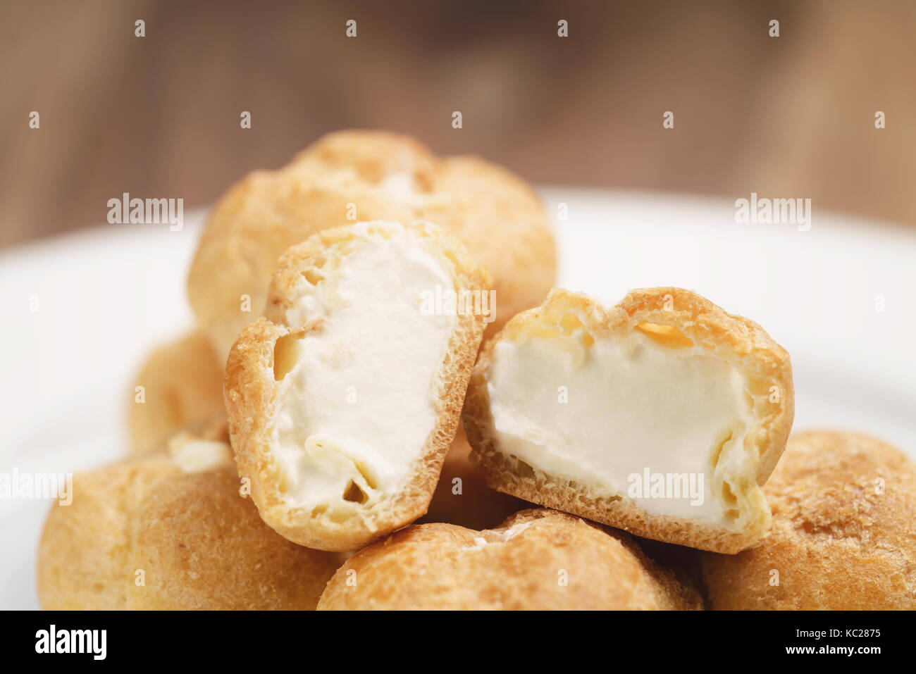 profiteroles on plate closeup one sliced, shallow focus Stock Photo - Alamy