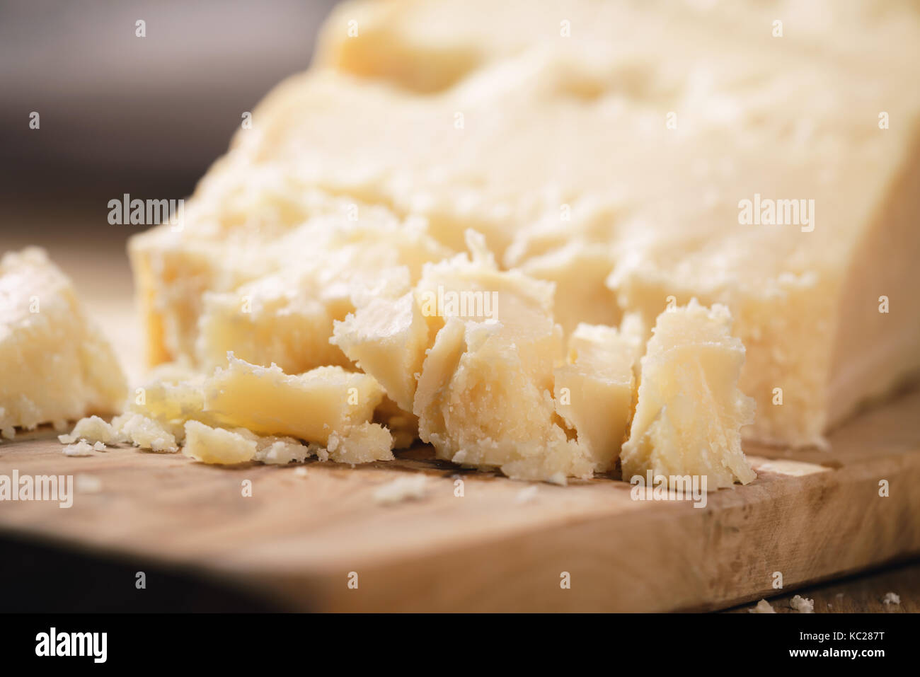 pieces of hard parmesan cheese on olive board, closeup Stock Photo - Alamy