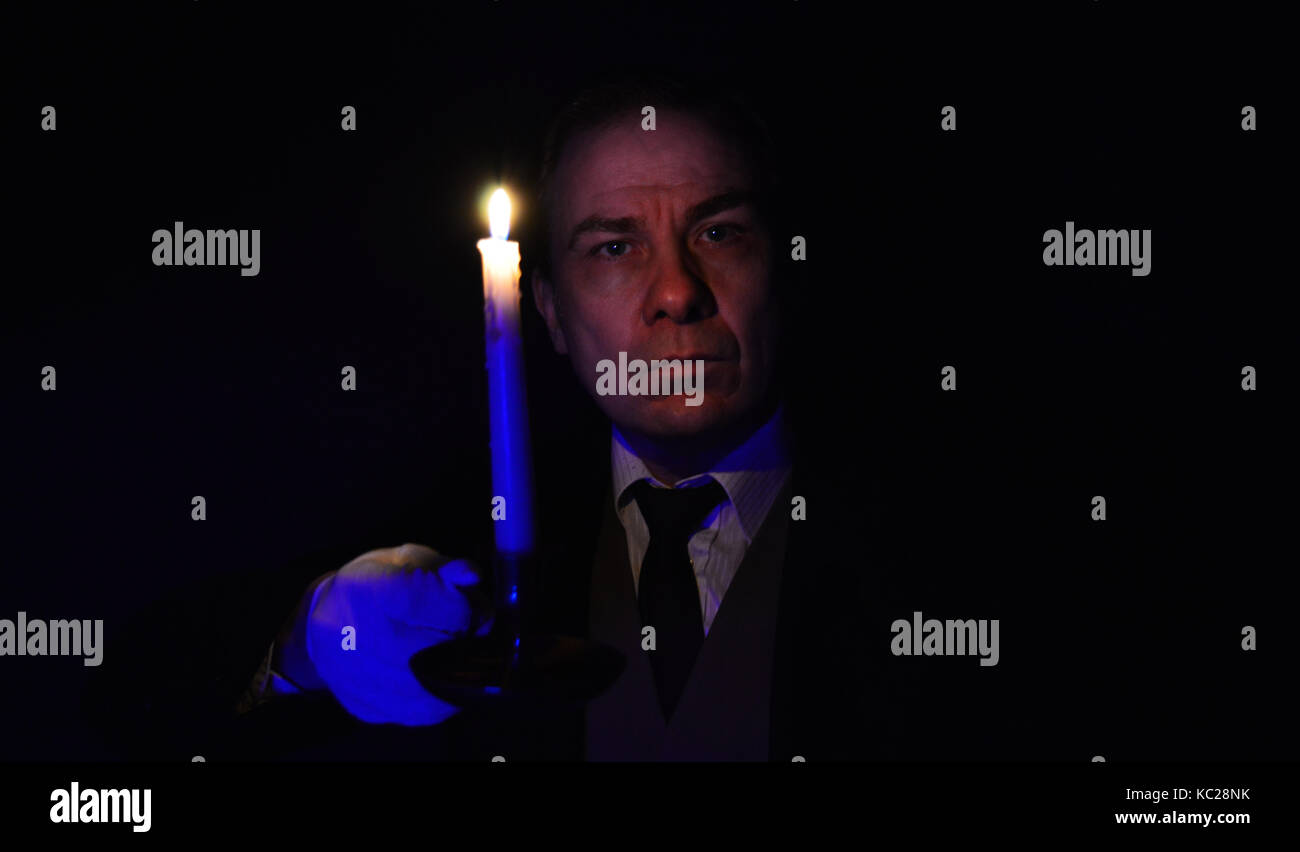 Butler with candle Stock Photo - Alamy