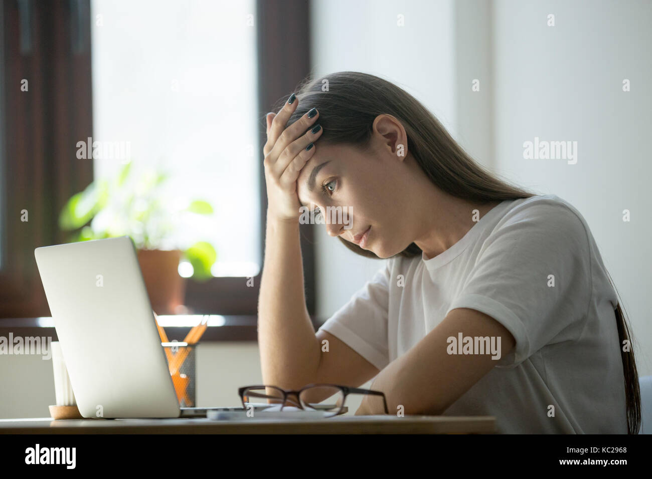 Woman looks at her laptop with a pained worried expression. Female ...