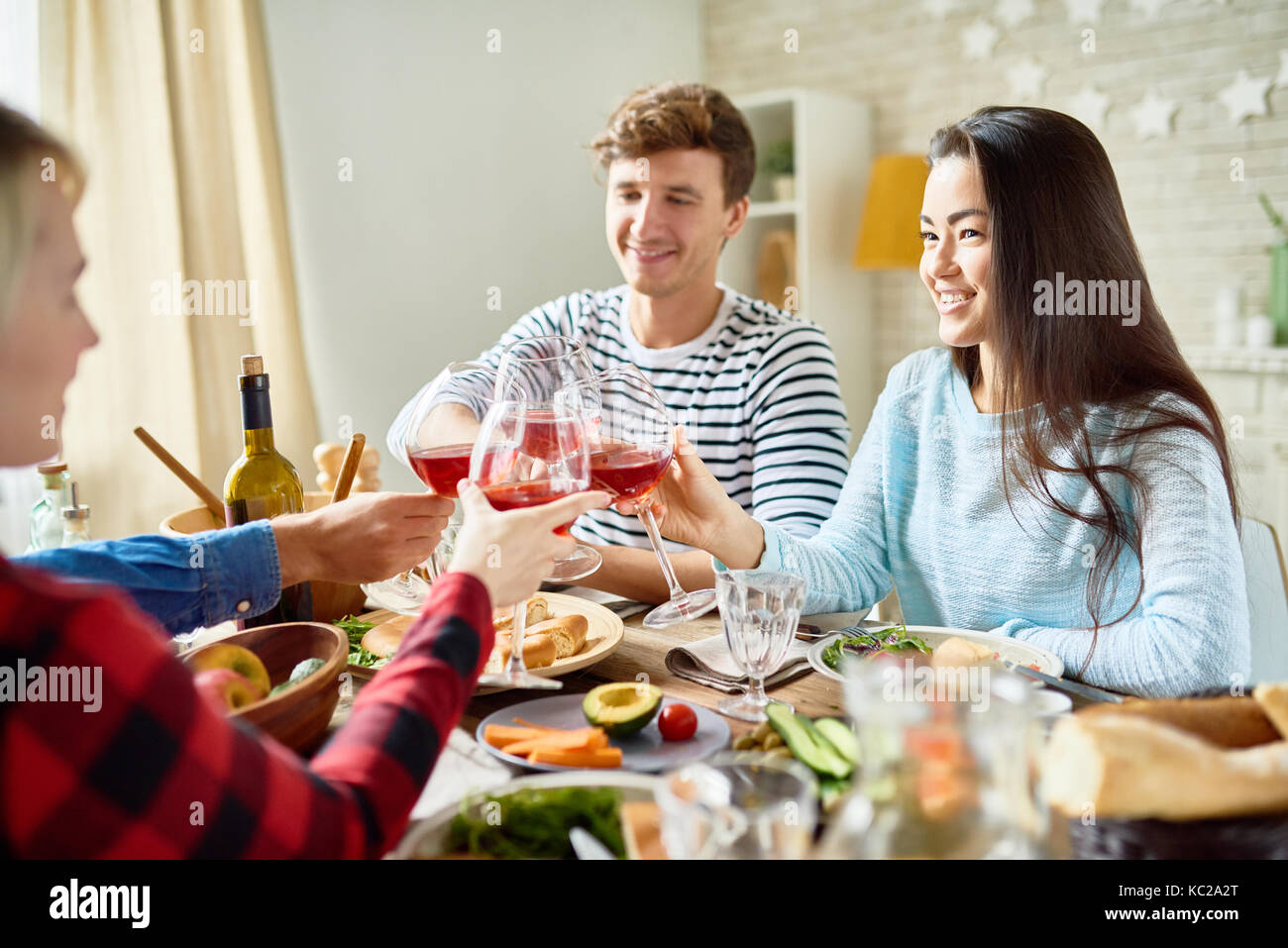 Group portrait of friends enjoying dinner together sitting at big table ...