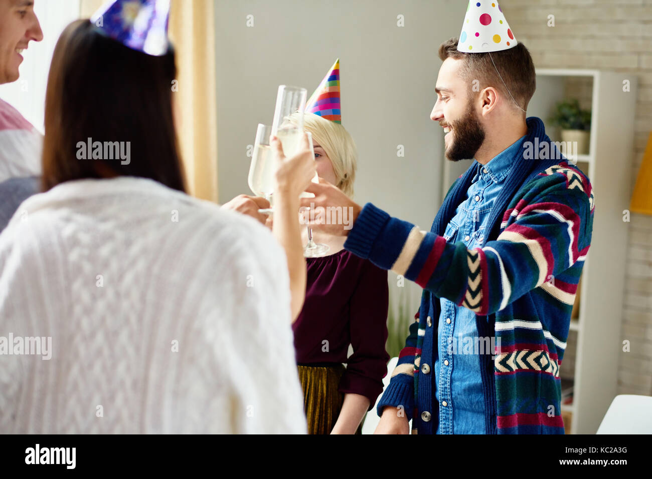 Group of happy young people wearing holiday caps celebrating Birthday ...