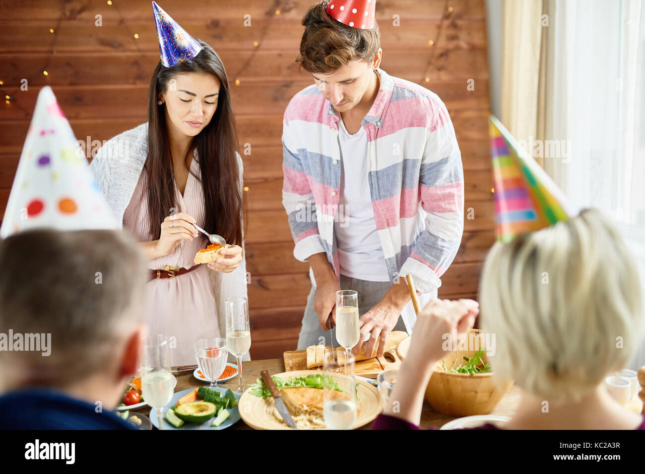 Group of modern young people wearing holiday caps celebrating Birthday ...