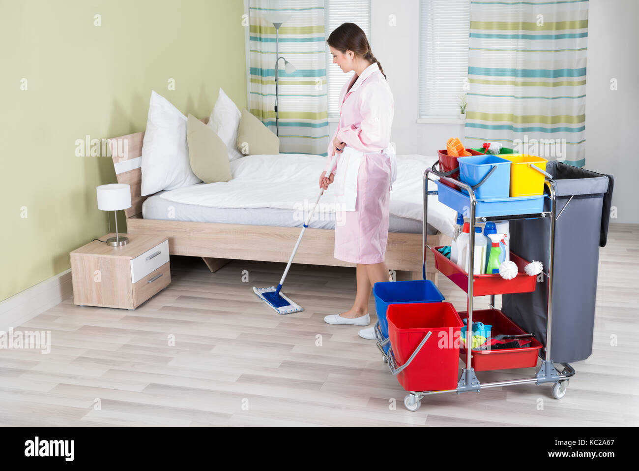 Young Female Housekeeper Mopping Floor In Room Stock Photo - Alamy