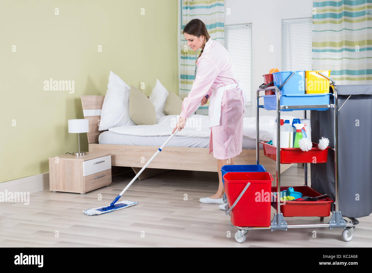 Young Female Housekeeper Mopping Floor In Room Stock Photo - Alamy