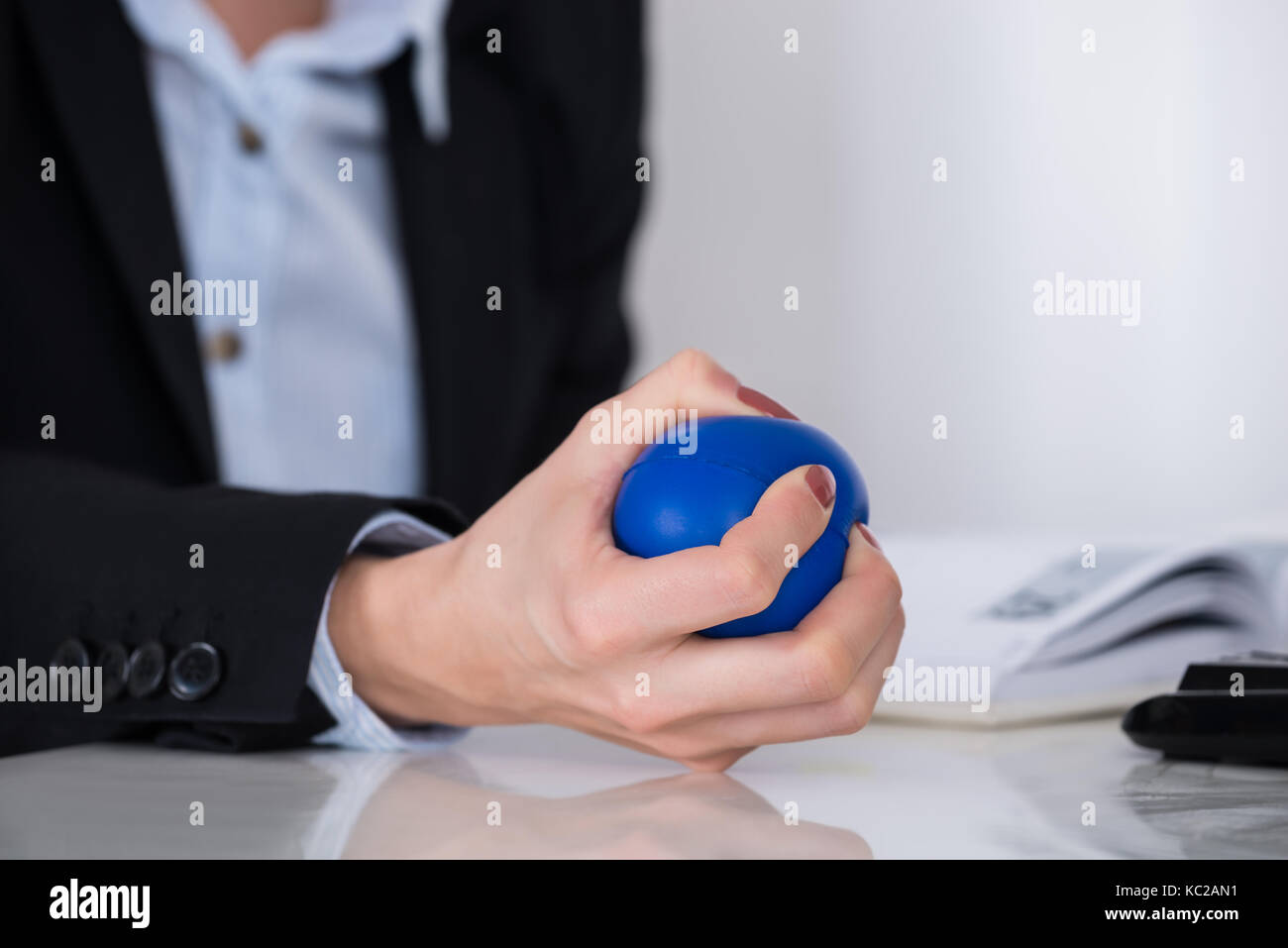 Close-up Of Businessperson Hand Squeezing Blue Stressball In Hand At ...