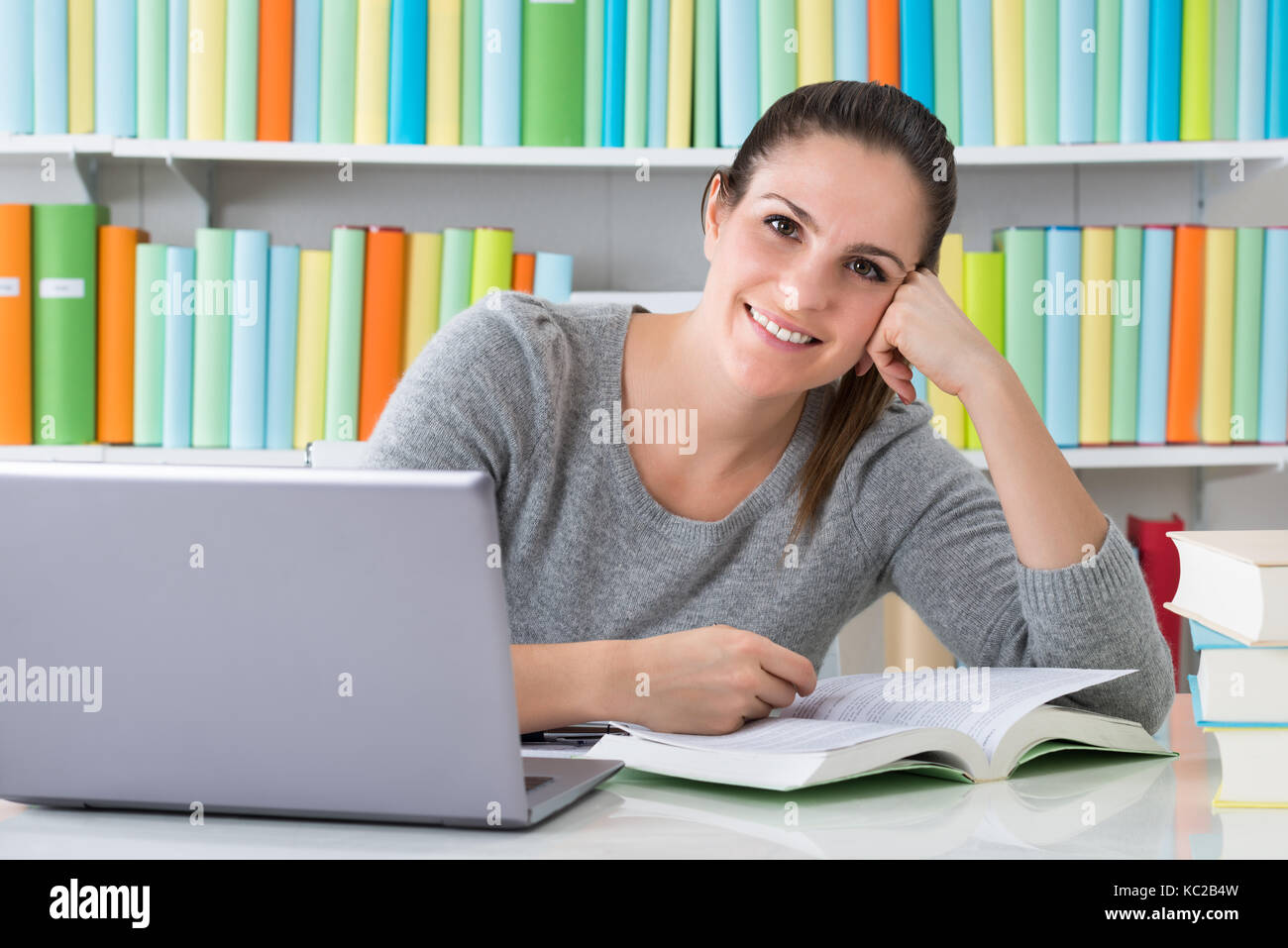 Photo Of Happy Young Woman Studying In Library Stock Photo - Alamy