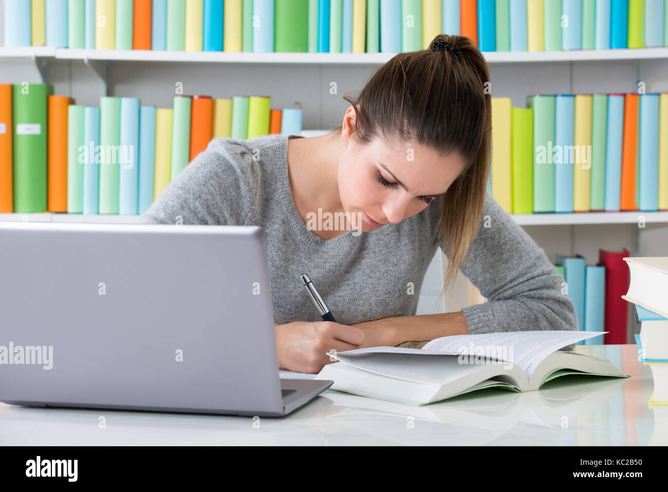 Photo Of Happy Young Woman Studying In Library Stock Photo - Alamy