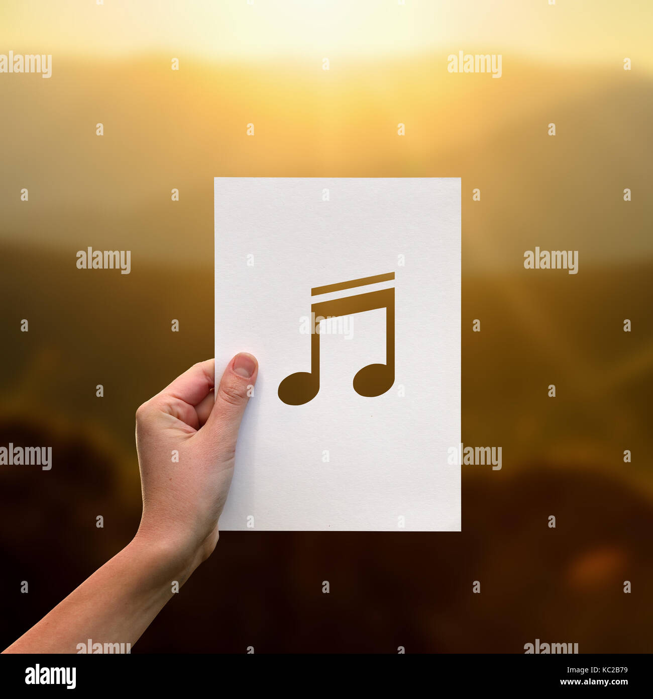 Female hand holding paper blank with sound of music perforated paper ...