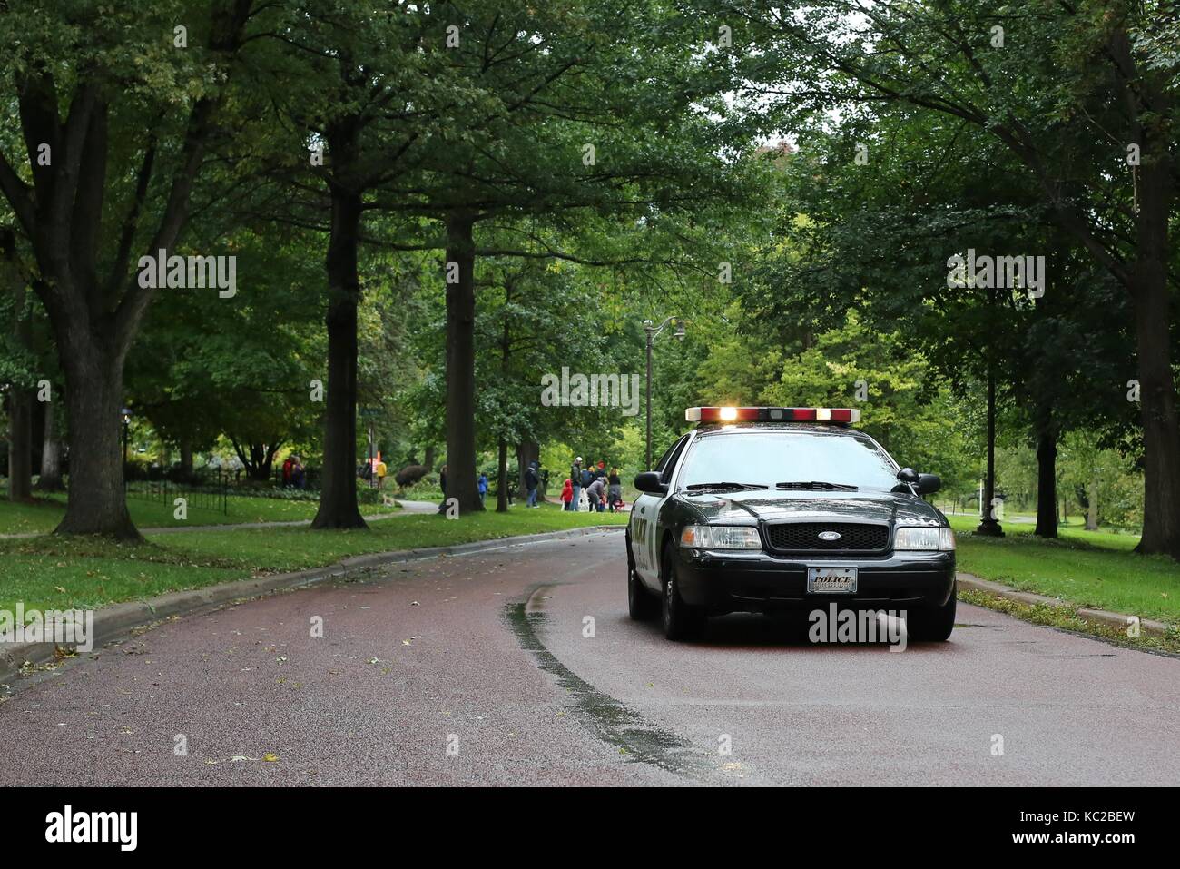 A police car with lights on, driving on a residential street in ...
