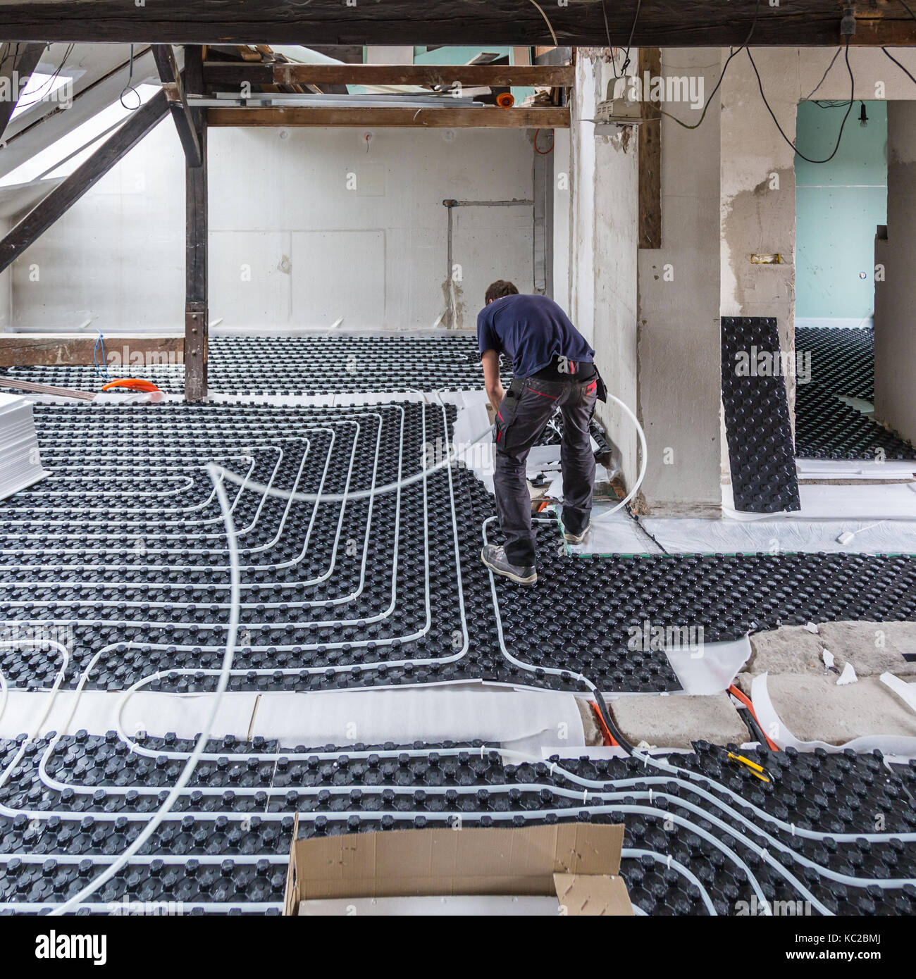 Pipe fitter mounting underfloor heating Stock Photo - Alamy