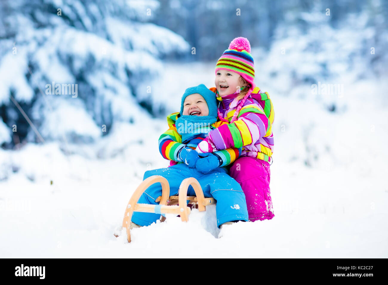 Little girl and boy enjoy a sleigh ride. Child sledding. Toddler kid ...