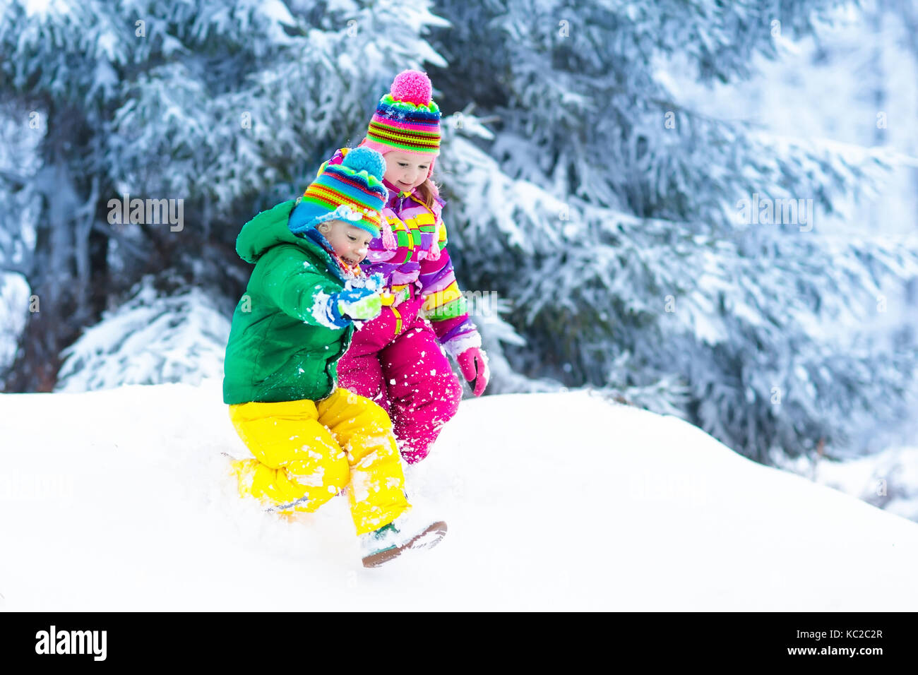 Kids playing in snow. Children play outdoors on snowy winter day. Boy ...