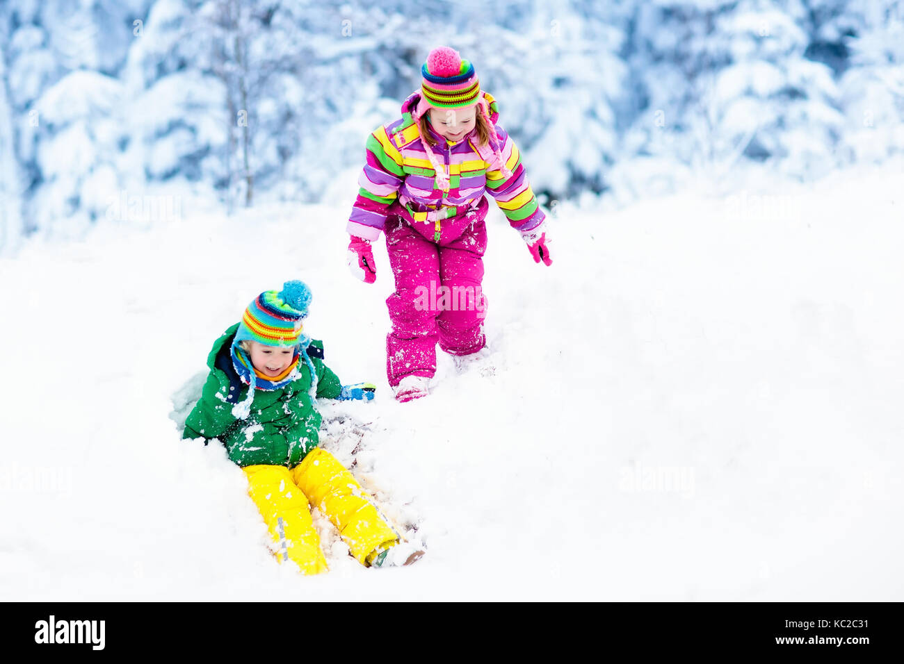 Kids playing in snow. Children play outdoors on snowy winter day. Boy ...