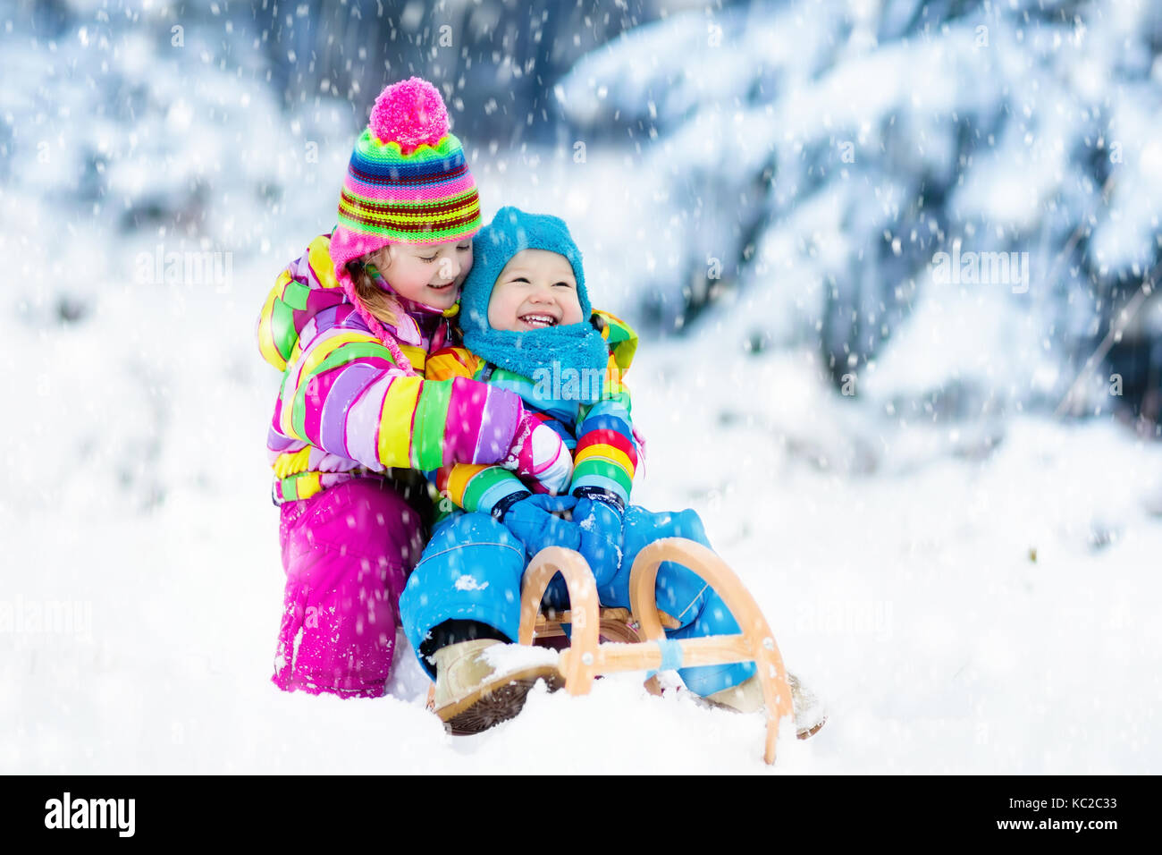 Little girl and boy enjoy a sleigh ride. Child sledding. Toddler kid ...
