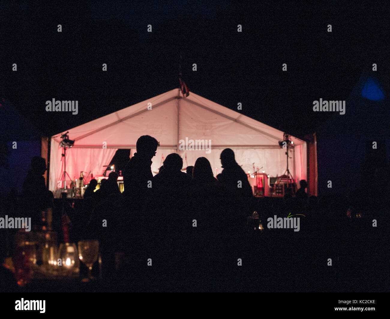 Group of figures in front of a brightly lit stage hi-res stock ...