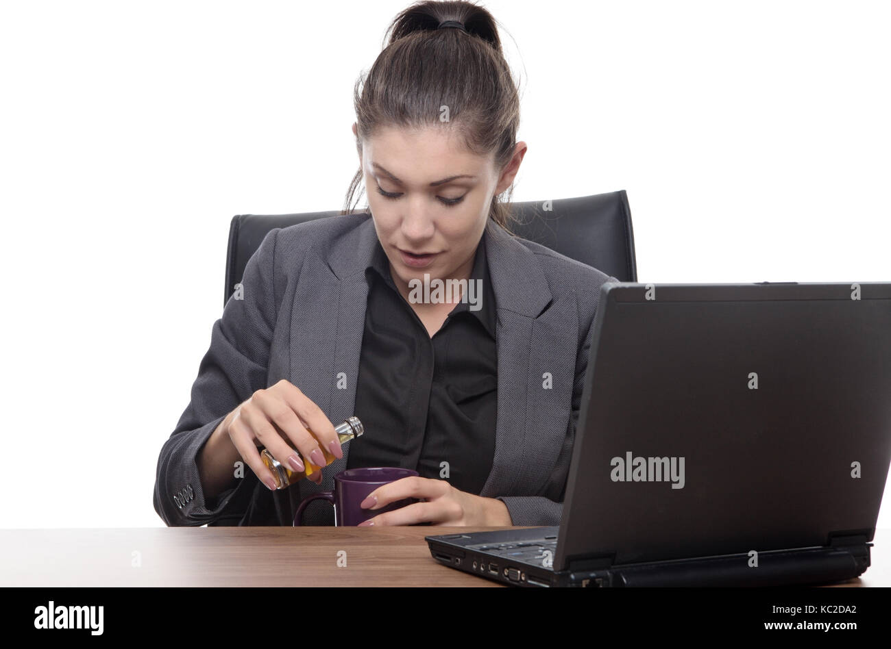 alcoholic business woman sneaking a drink at work sitting at her desk ...