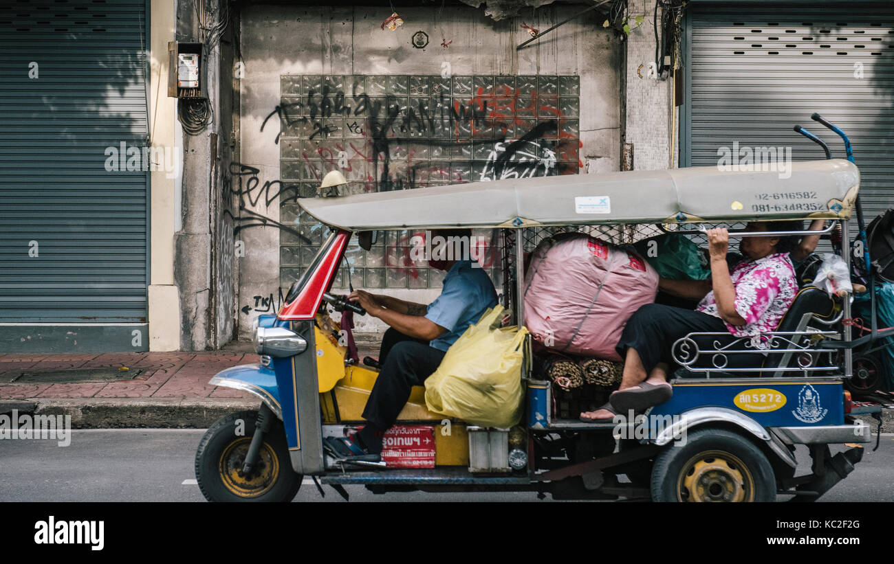 A tuk tuk transports passengers and their luggage through the streets ...