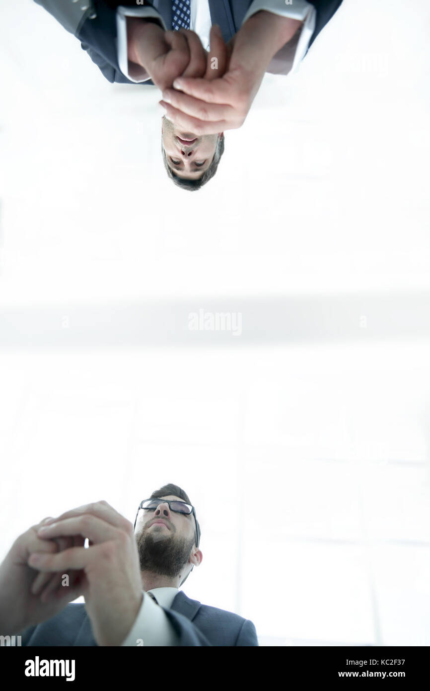 View from below. From behind the glass. Two businessmen sitting at the ...