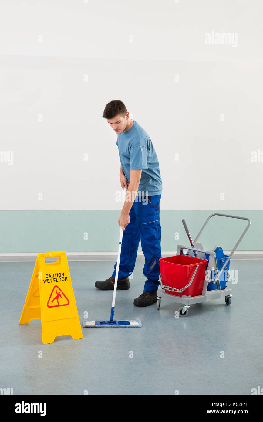 Young Male Worker With Cleaning Equipments Mopping Floor Stock Photo ...