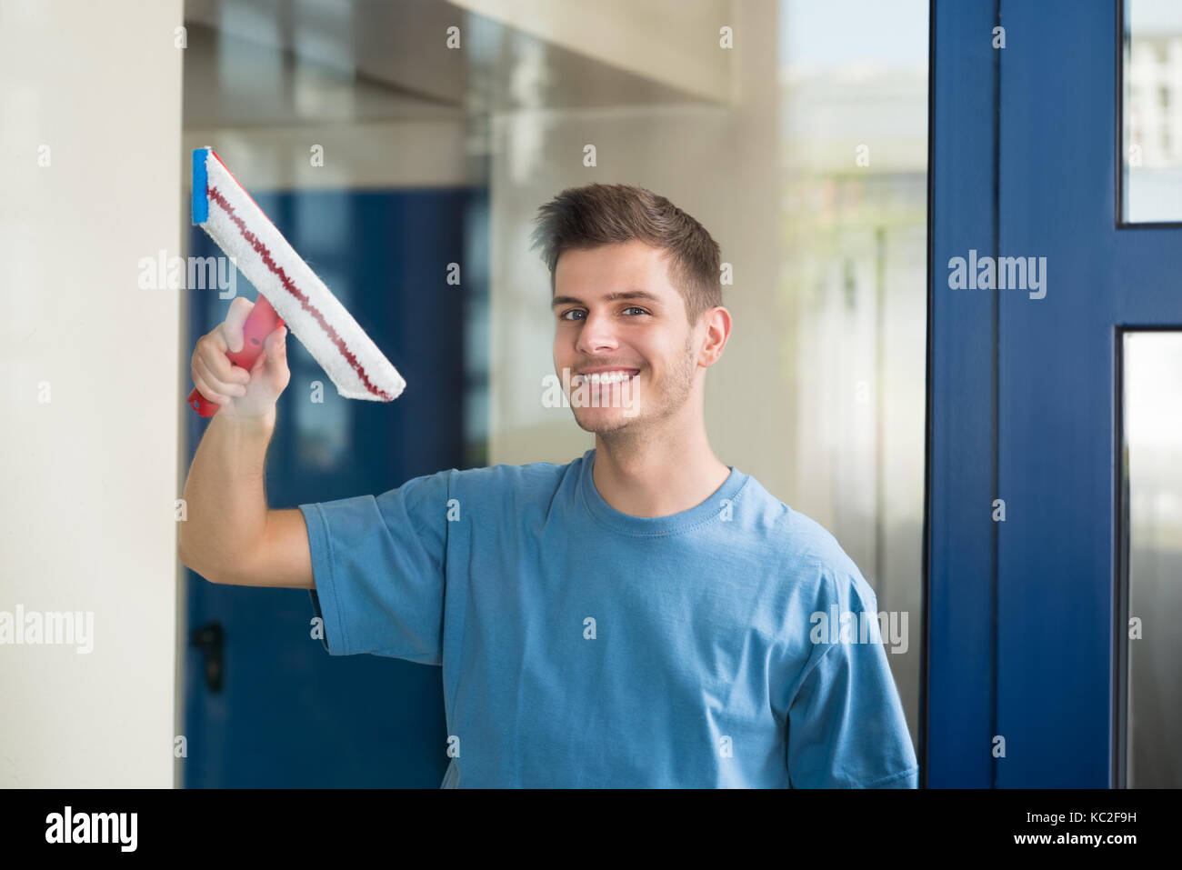 Young Happy Worker Cleaning Glass With Mop Stock Photo - Alamy