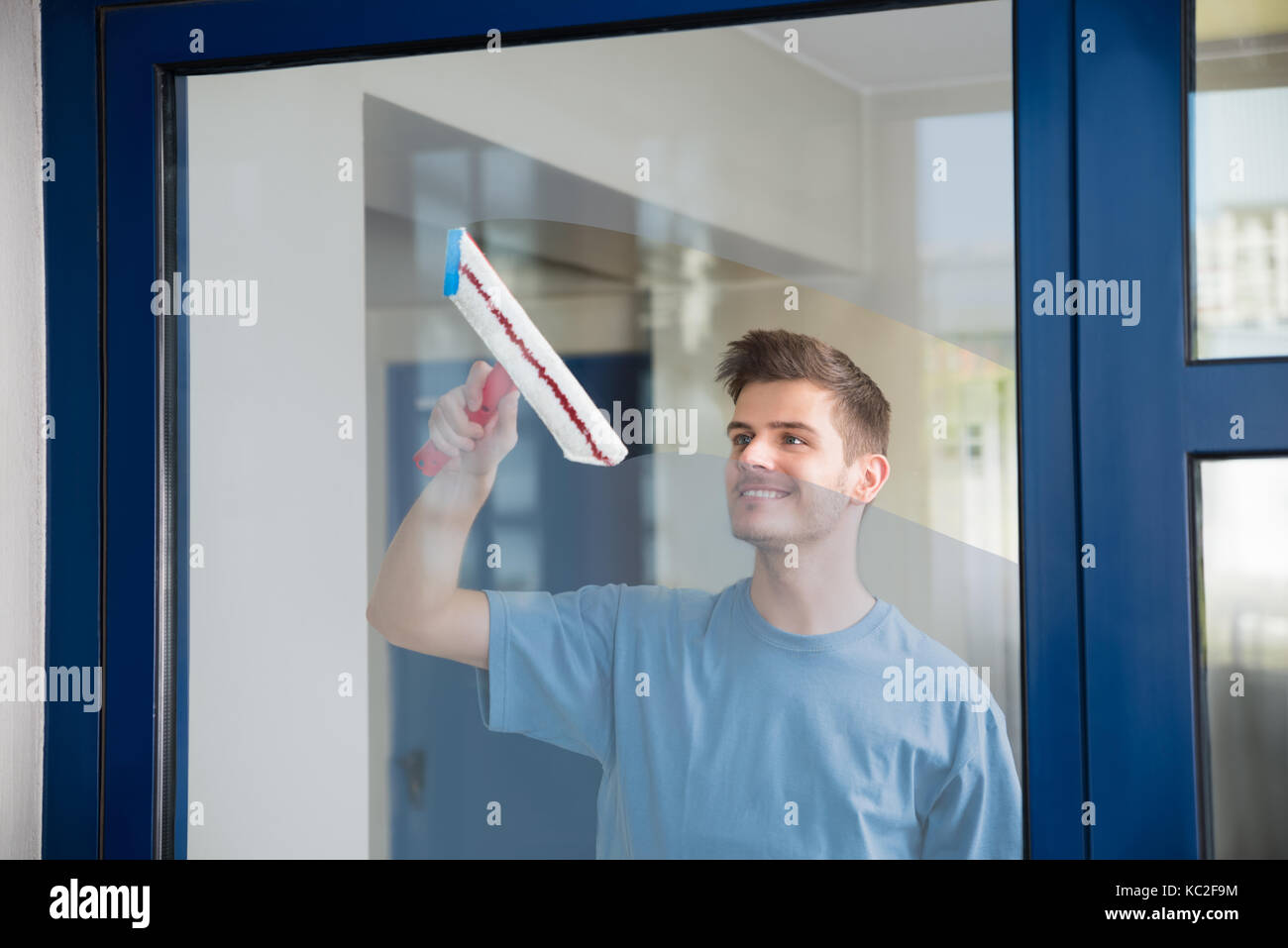 Young Happy Worker Cleaning Glass With Mop Stock Photo - Alamy