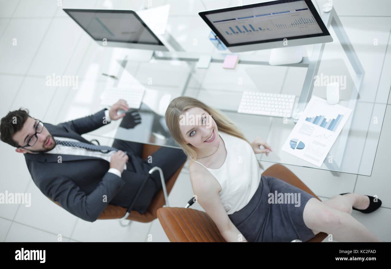 experienced company employees sitting at the desk and looking at the ...