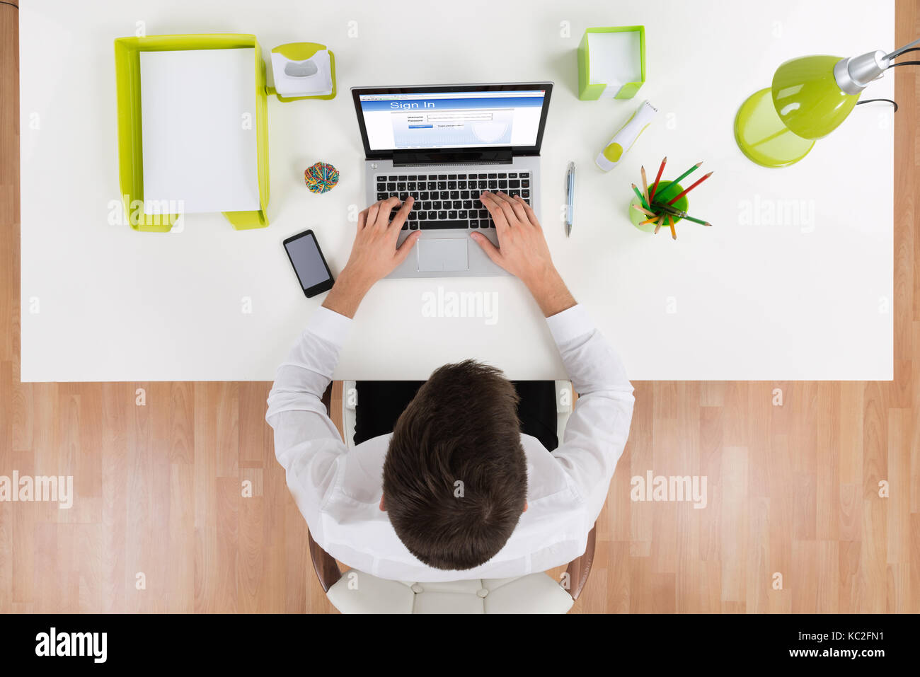 High Angle View Of Businessman Looking At Sign-in App On Laptop At Desk ...