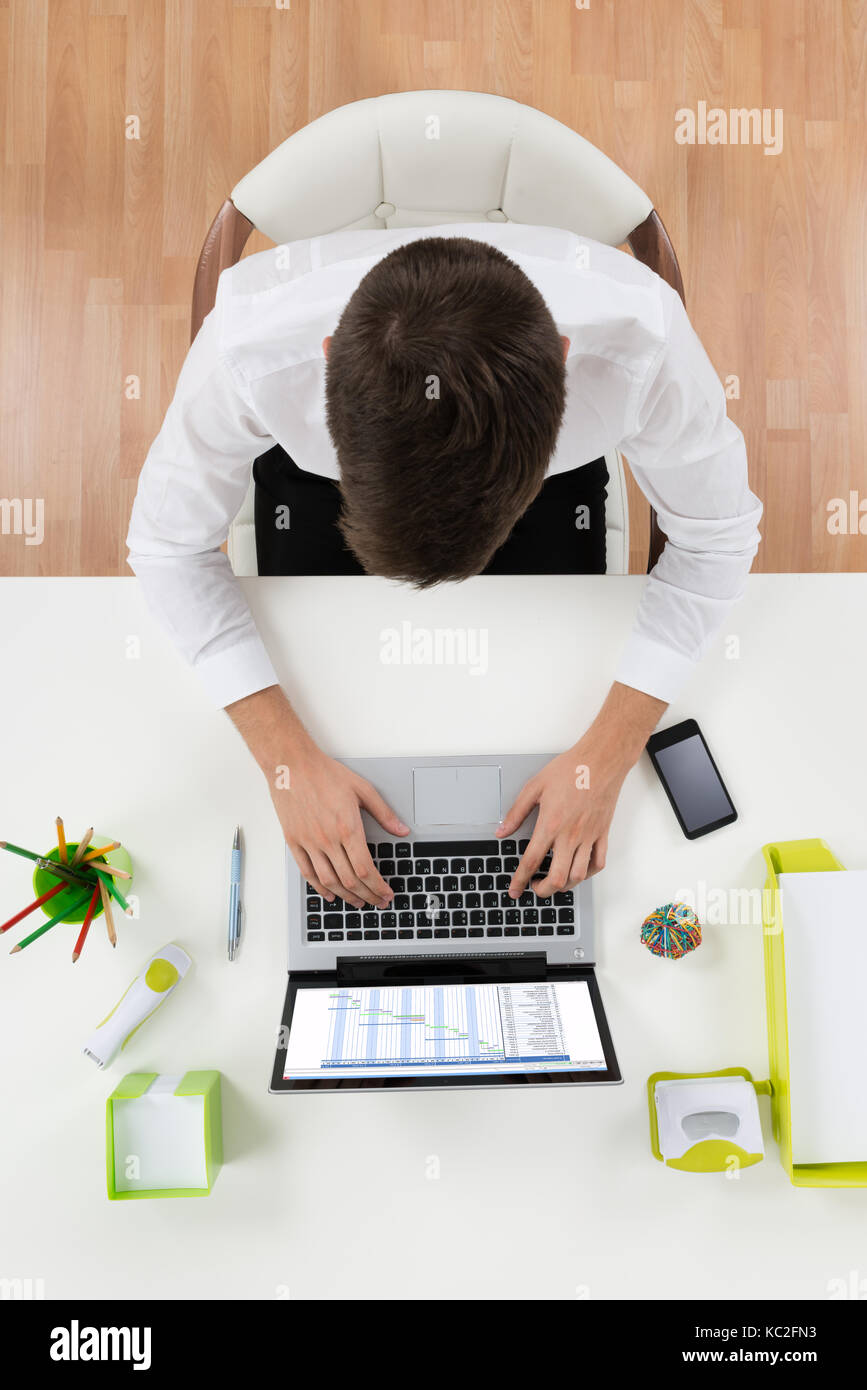 High Angle View Of Businessman Working On Laptop Showing Gantt Chart At ...
