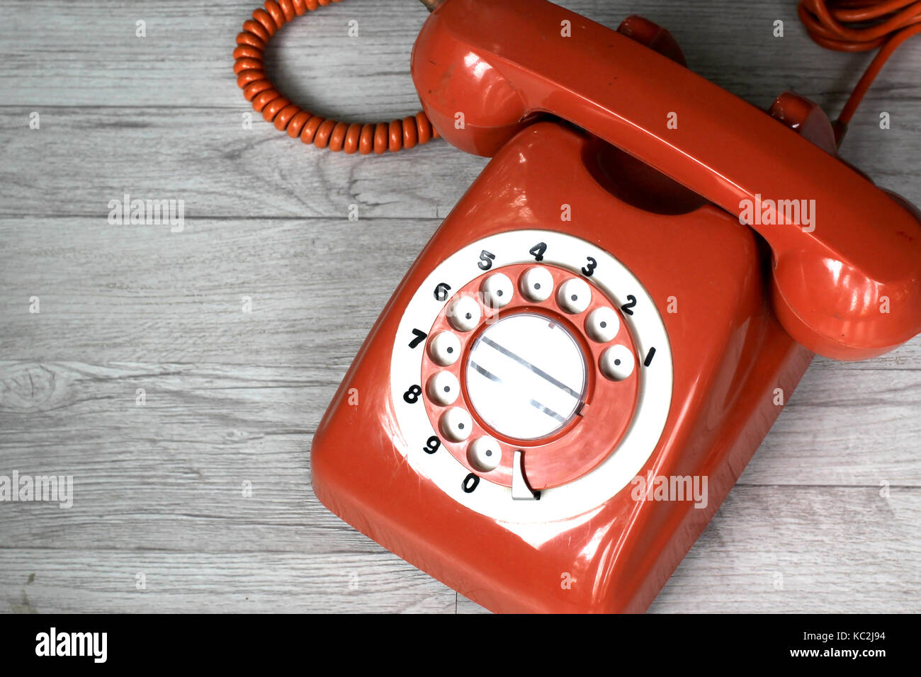 old dirty orange telephone on wooden table Stock Photo - Alamy