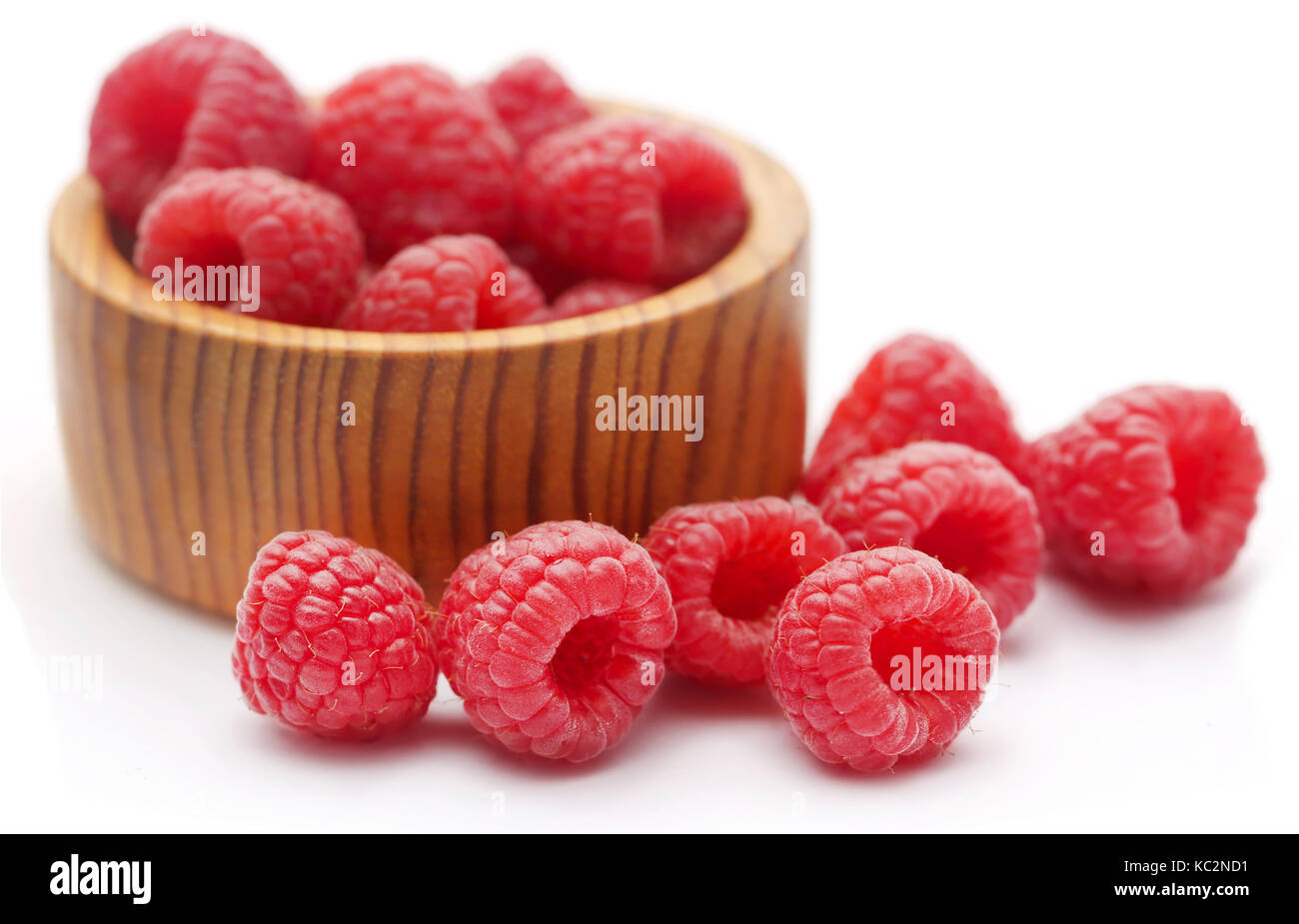 Fresh Raspberries in a wooden bowl over white background Stock Photo ...