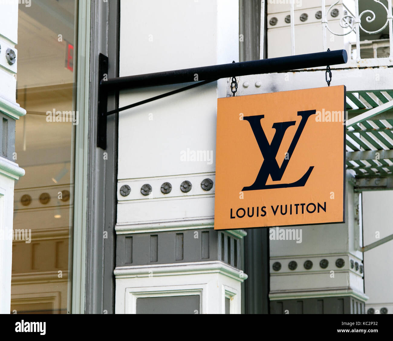 Louis Vuitton banner is suspended above the entrance to their store in ...