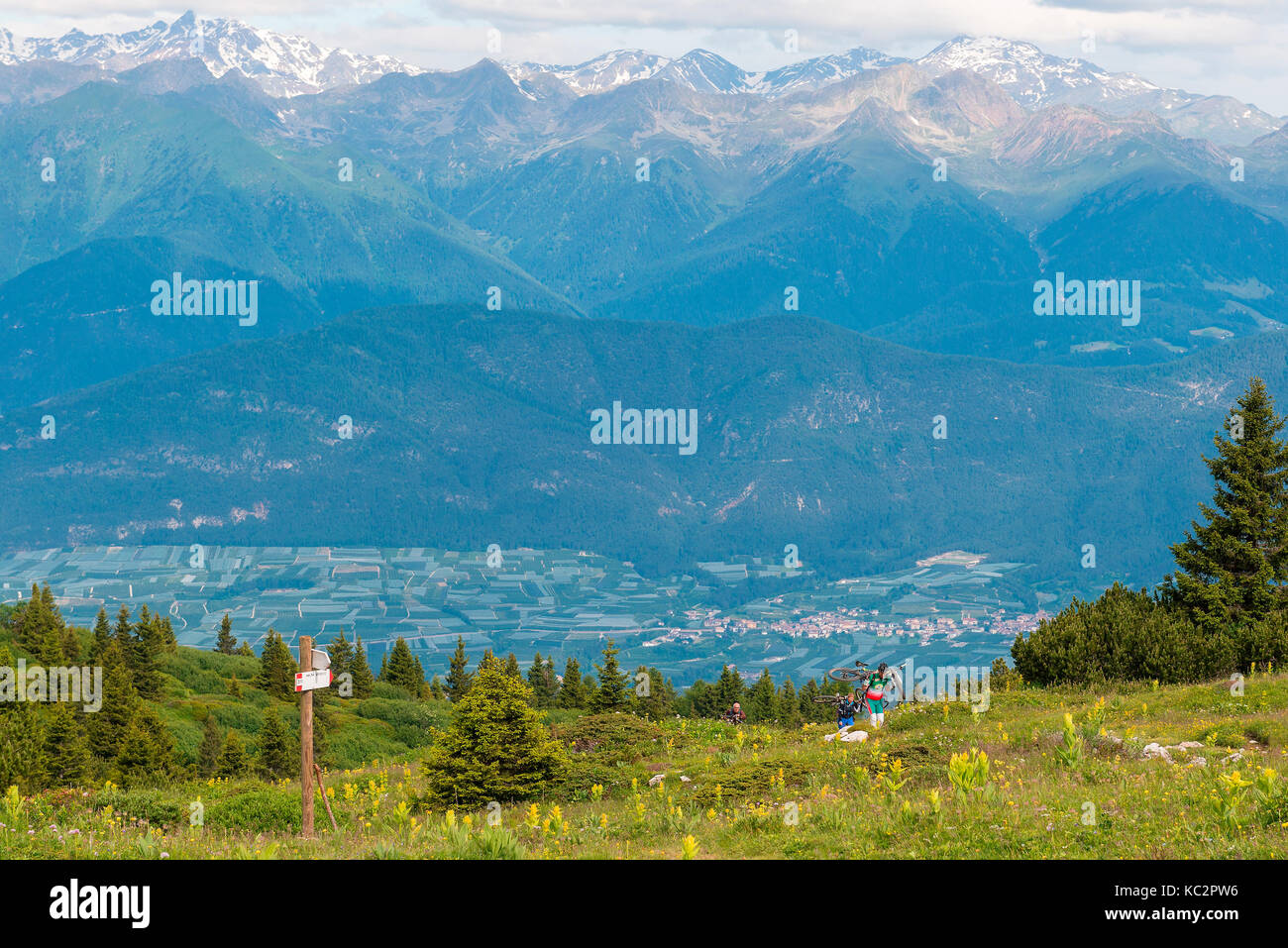Bikers on top of Roen Mount, with some peaks of Maddalene group still ...
