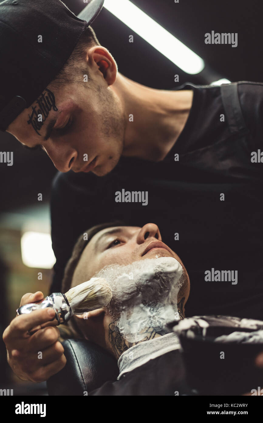 Barber shaving client Stock Photo - Alamy