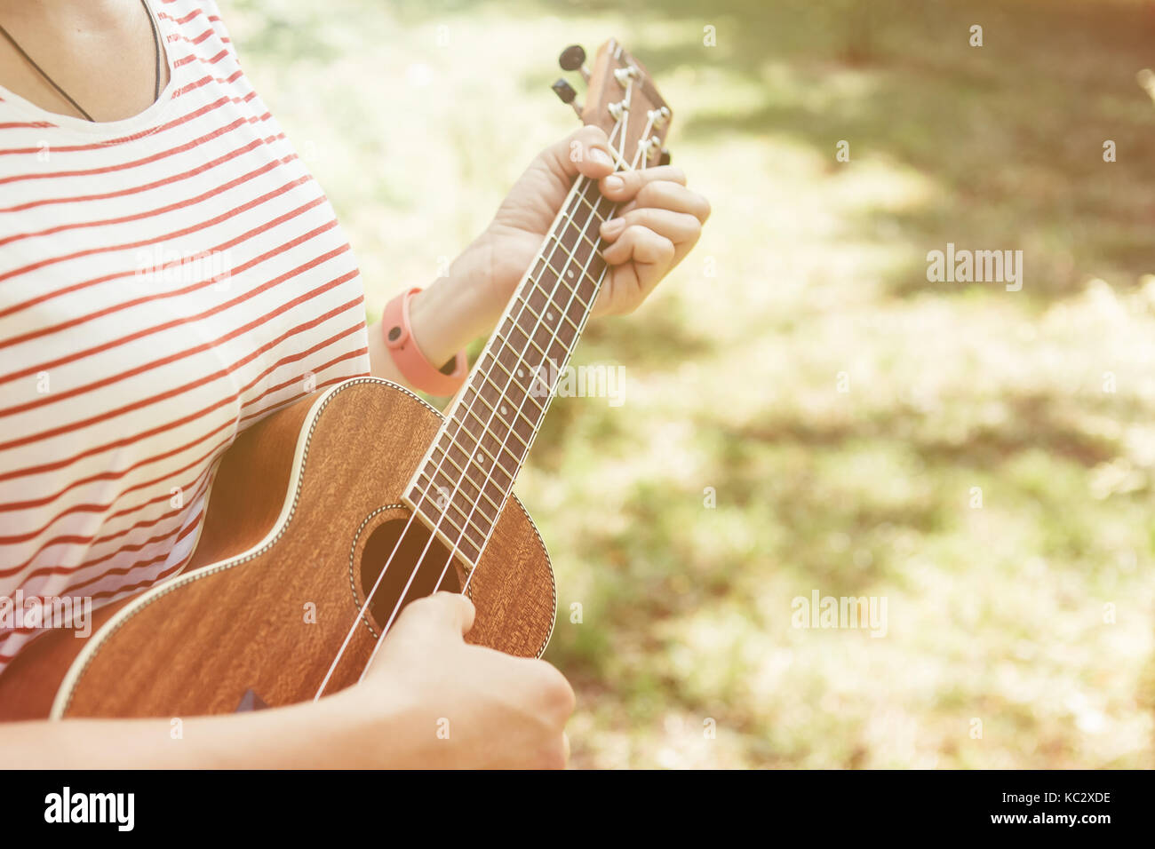 Anonymous woman playing ukulele Stock Photo - Alamy