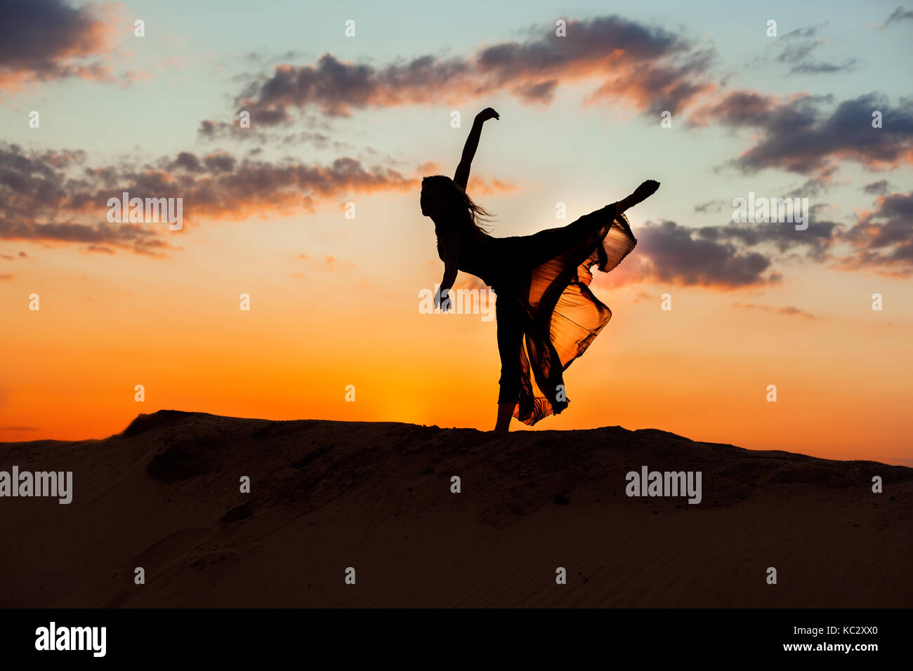 Dancing at night in the sand against the backdrop of the setting sun ...