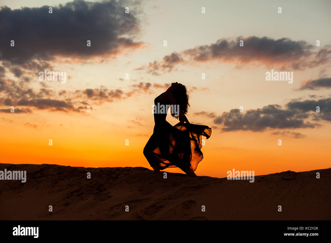 Female figure during a dance against the backdrop of the setting sun ...