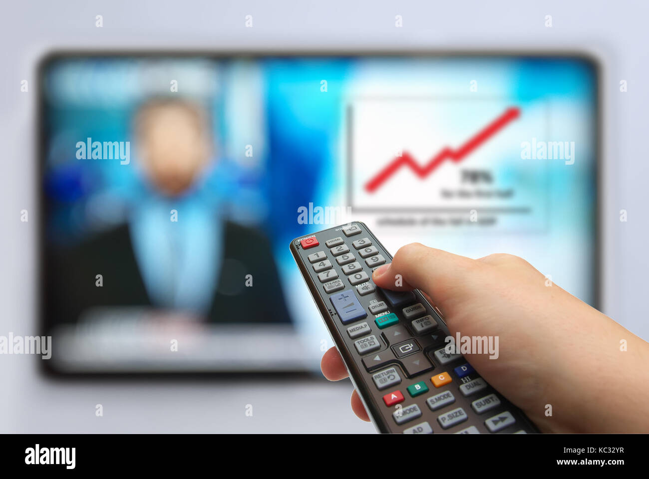 Man hand switches TV channels. Remote control in hand and TV. News in ...