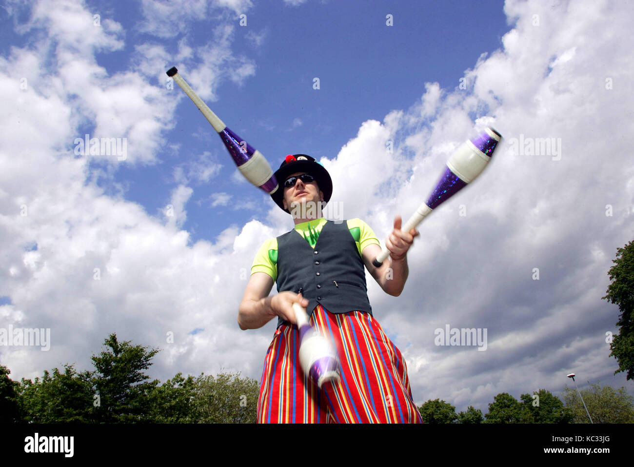A juggler juggling against a blue sky Stock Photo - Alamy