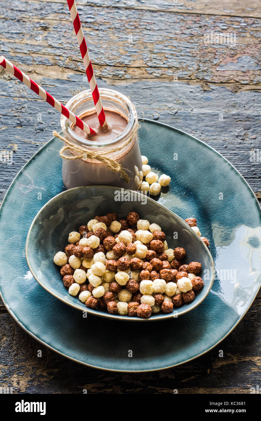 Healthy breakast corn flakes in a bowl and glass of milk on rustic ...