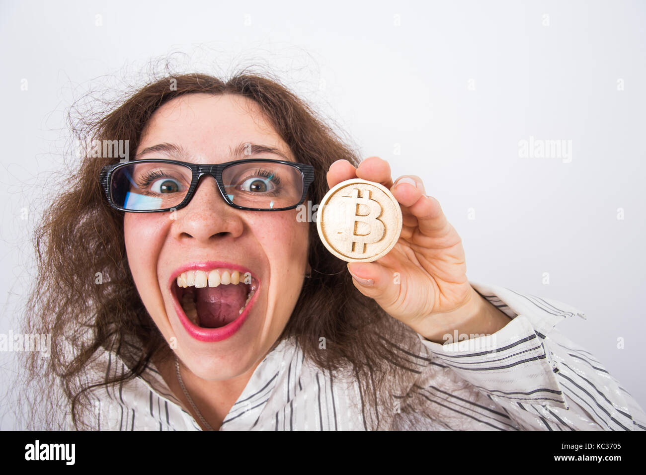 Surprised business woman showing Golden Bitcoin coin and thumbs up ...