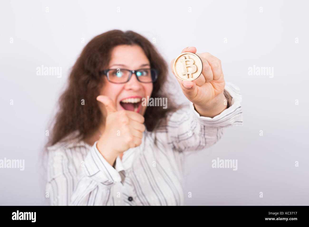 Surprised business woman showing Golden Bitcoin coin and thumbs up ...